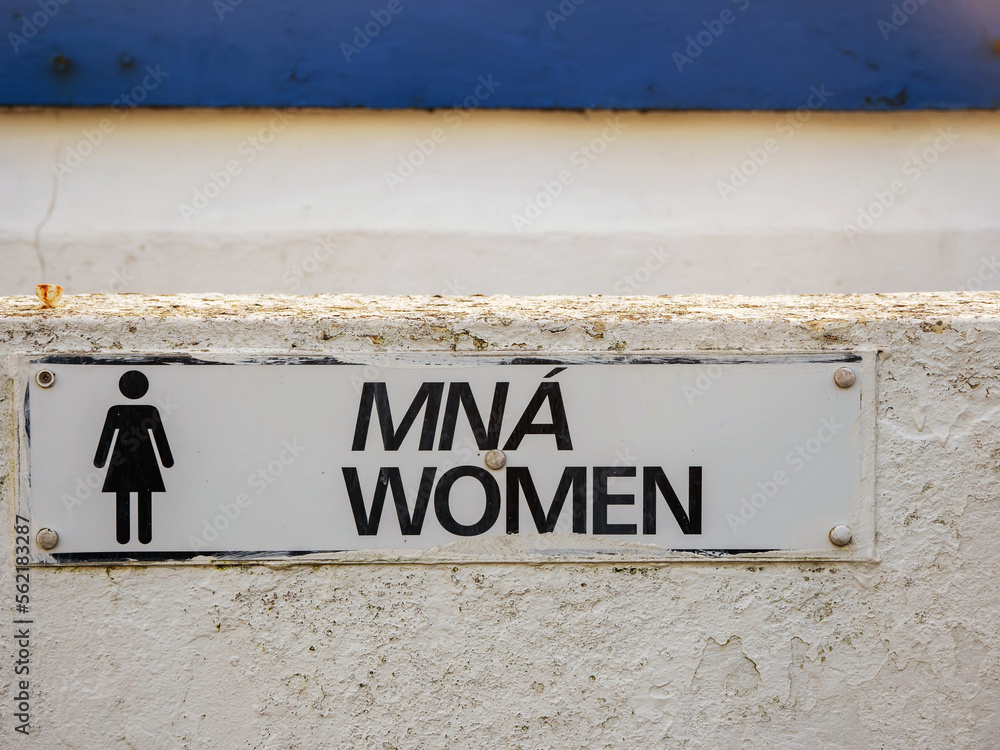 Sign women in Irish and English language on a changing room by a beach ...