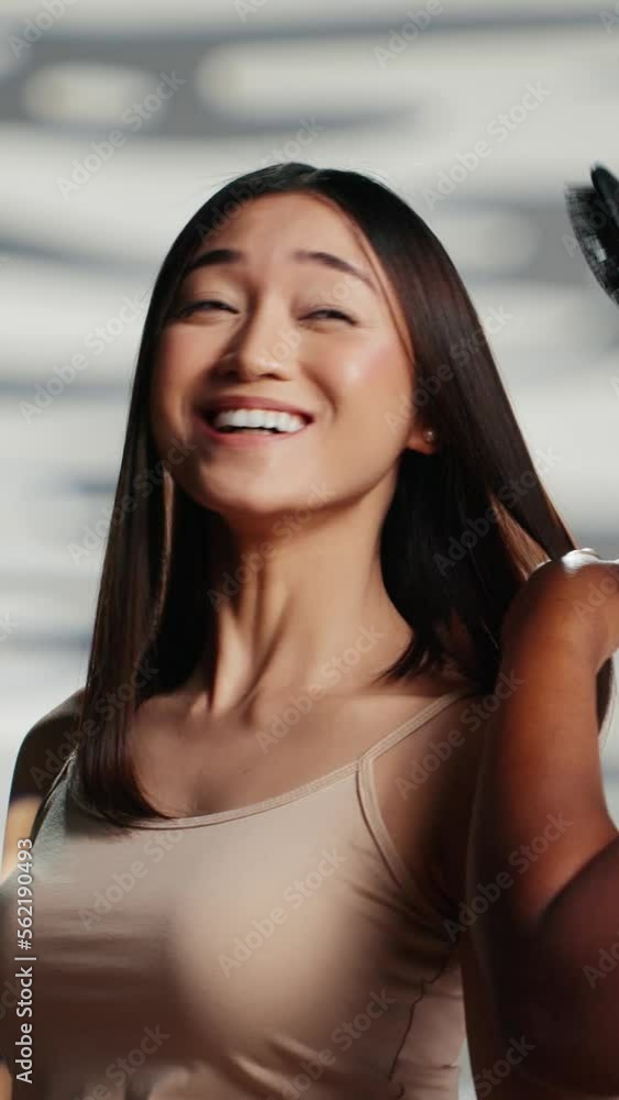 Vertical video: Confident person brushing hair of asian woman, using ...