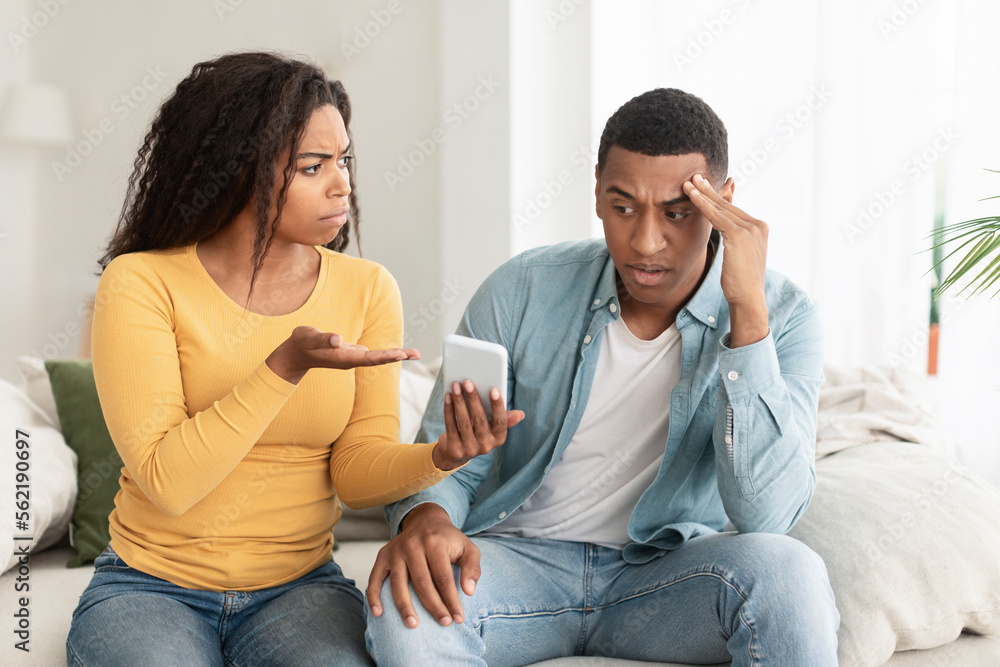 Unhappy jealous angry young african american wife show smartphone to ...