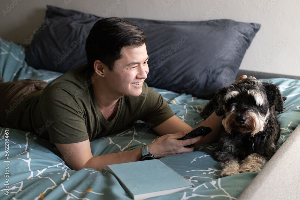 Trans person with a dog at home on bed Stock Photo | Adobe Stock
