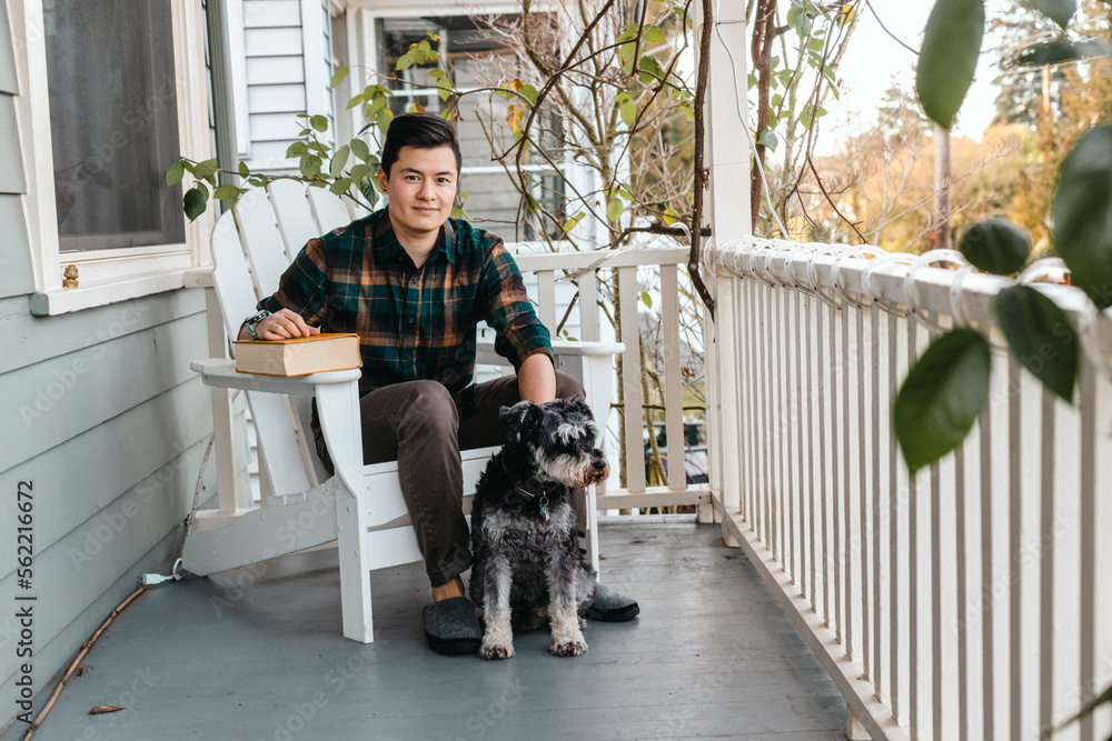 Transgender man with dog on his porch. Stock Photo | Adobe Stock