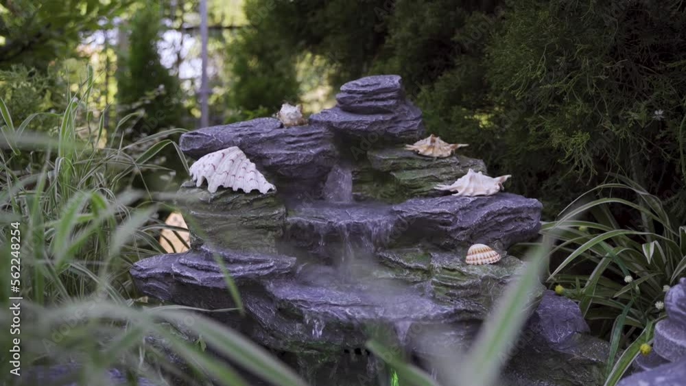 Water cascade in the garden. Pure water flows through the cascade of an ...