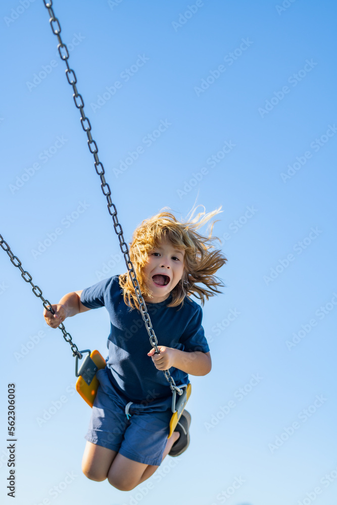 Childhood. Funny kid on swing. Little boy swinging on playground. Happy cute excited child on ...