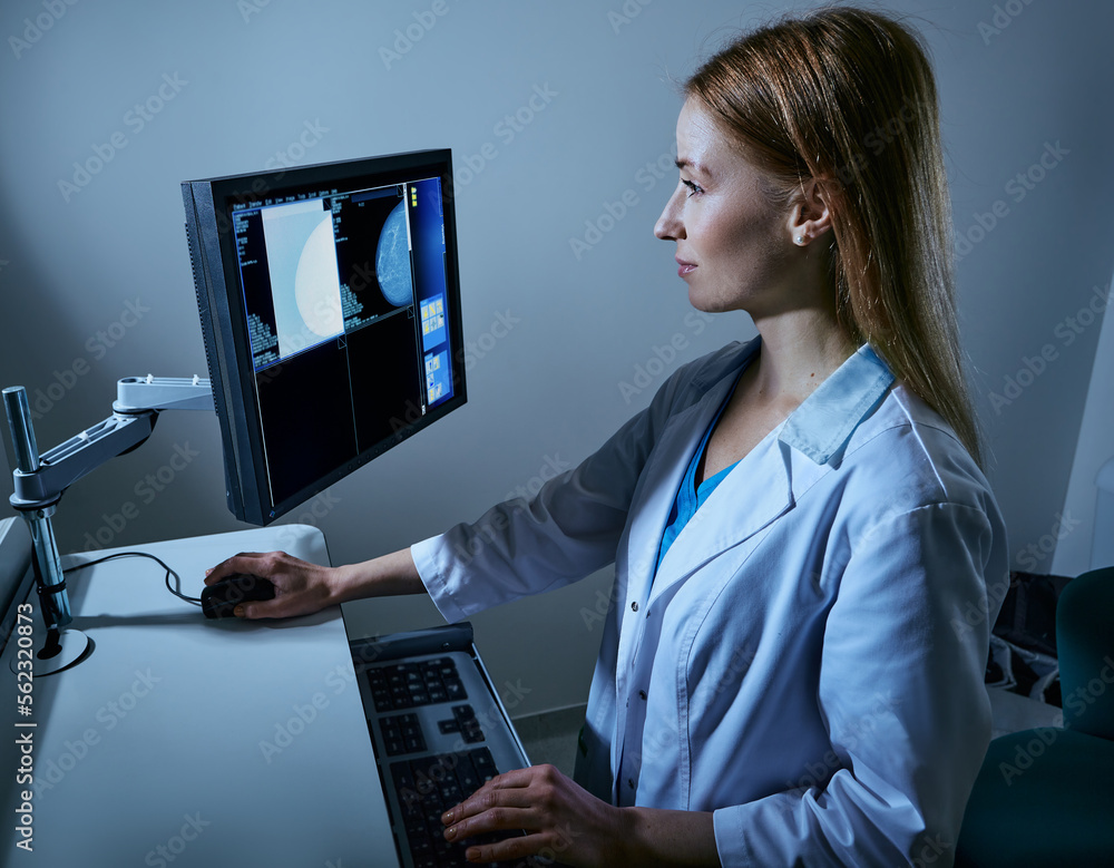 Mammogram being performed. Female medical technician looking in monitor ...