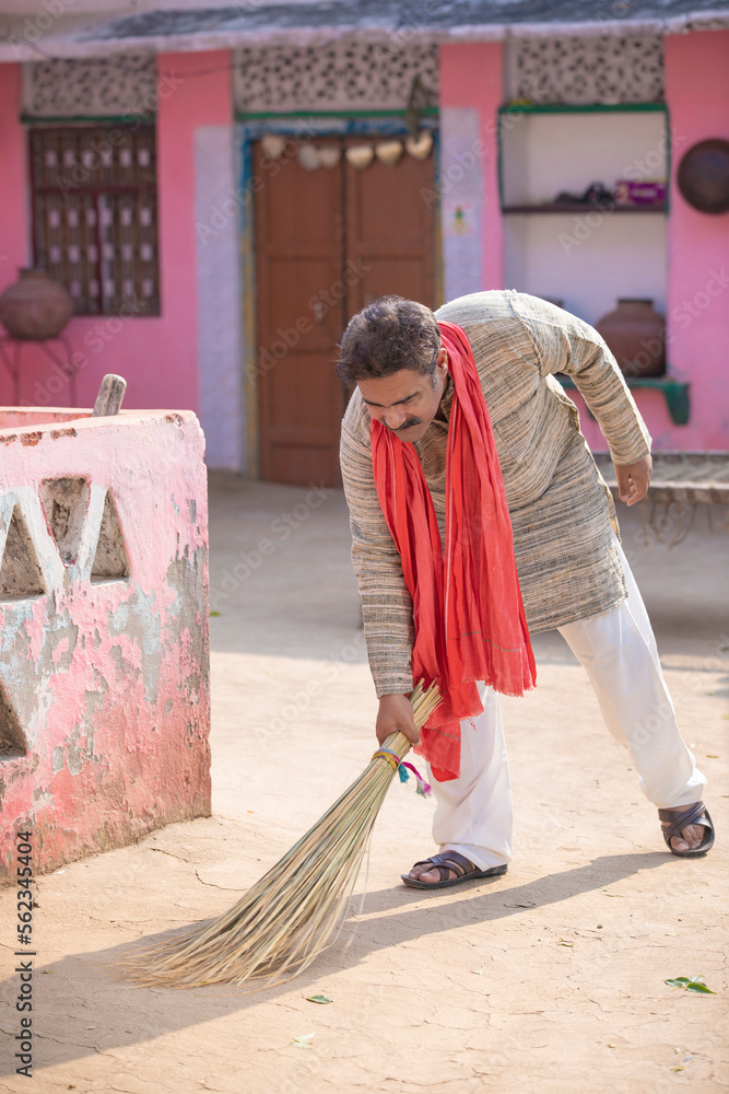 Indian man cleaning house with broom Stock Photo | Adobe Stock