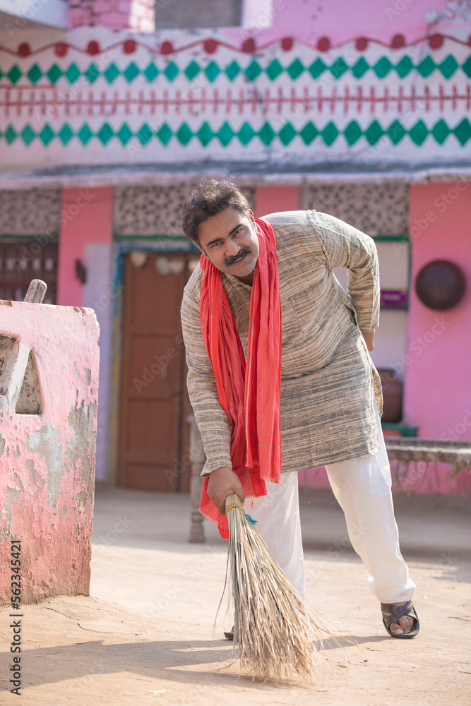 Indian man cleaning house with broom Stock Photo | Adobe Stock