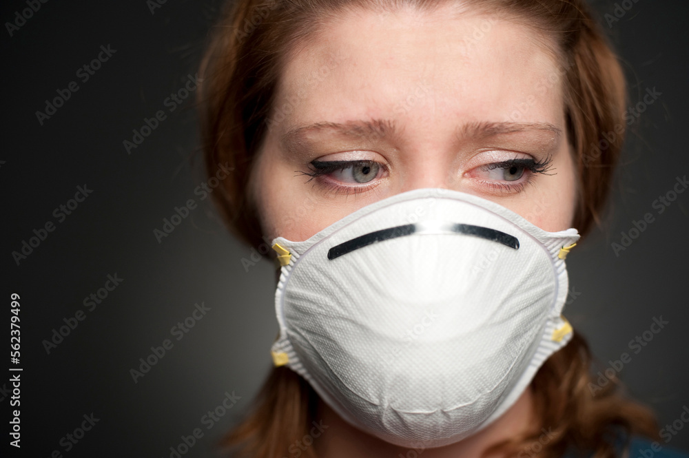 Studio portrait of 24 year old caucasian female wearing a N95 mask ...