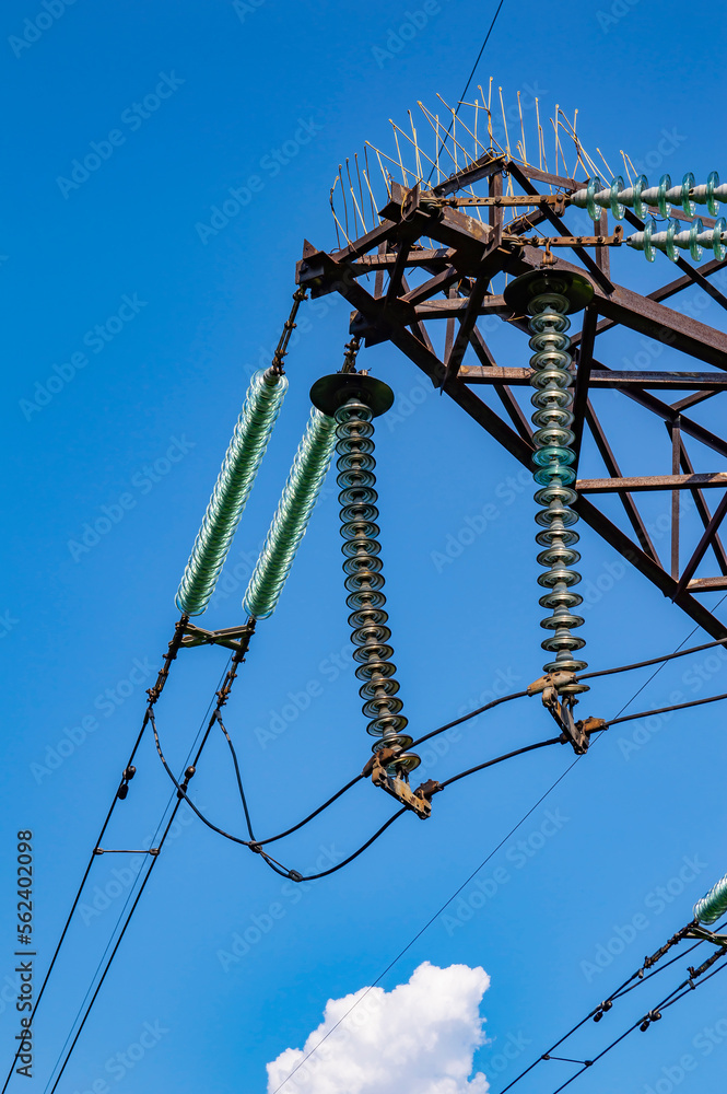 Line insulator on the electrical wires of a high-voltage tower ...