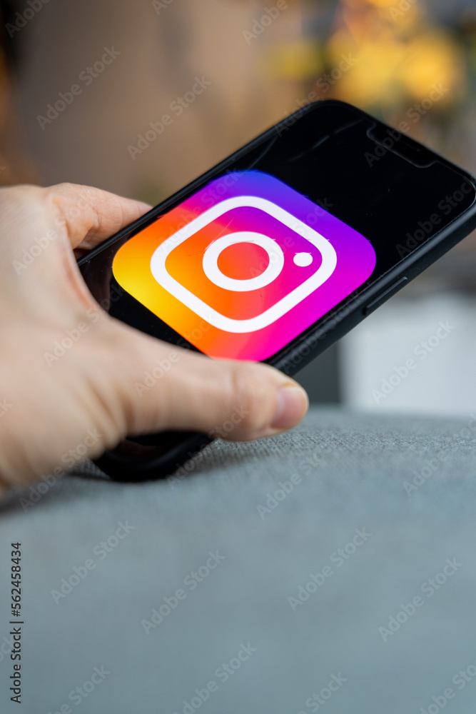 Hand holding a smartphone with an Instagram icon on screen. IPhone with ...