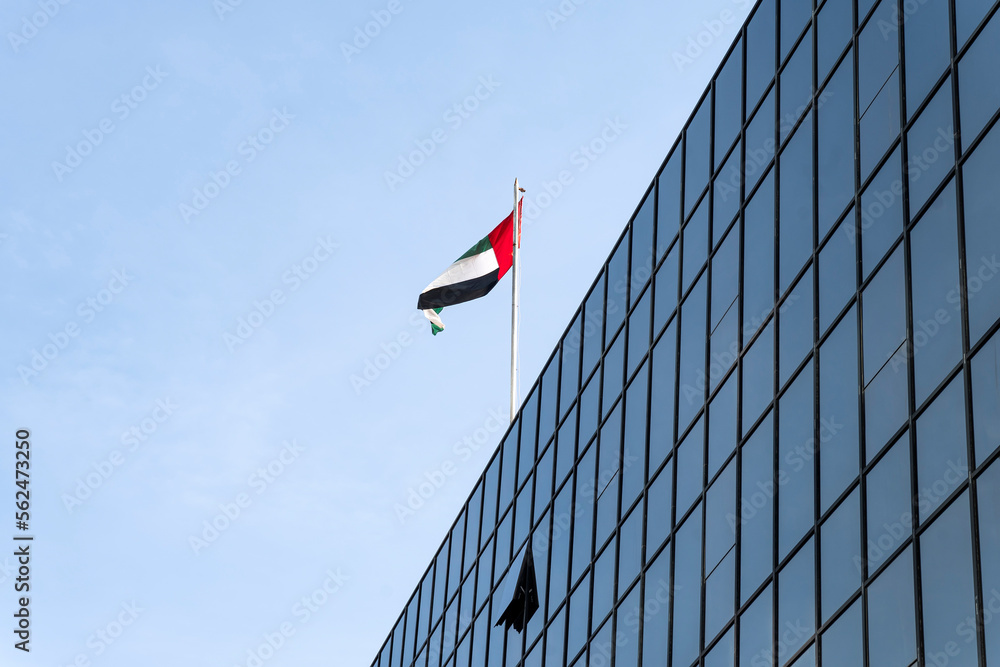 the flag of the UAE on a blue sky background. Flag waving at the top of ...