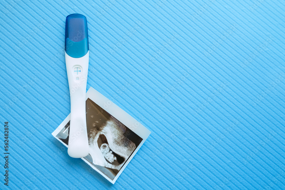 Positive pregnancy test with two strips with ultrasound picture of the ...