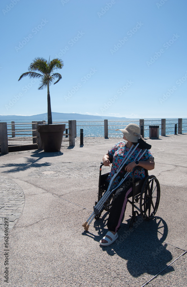 beautiful young amputee woman with crutches sitting on a wheelchair on ...