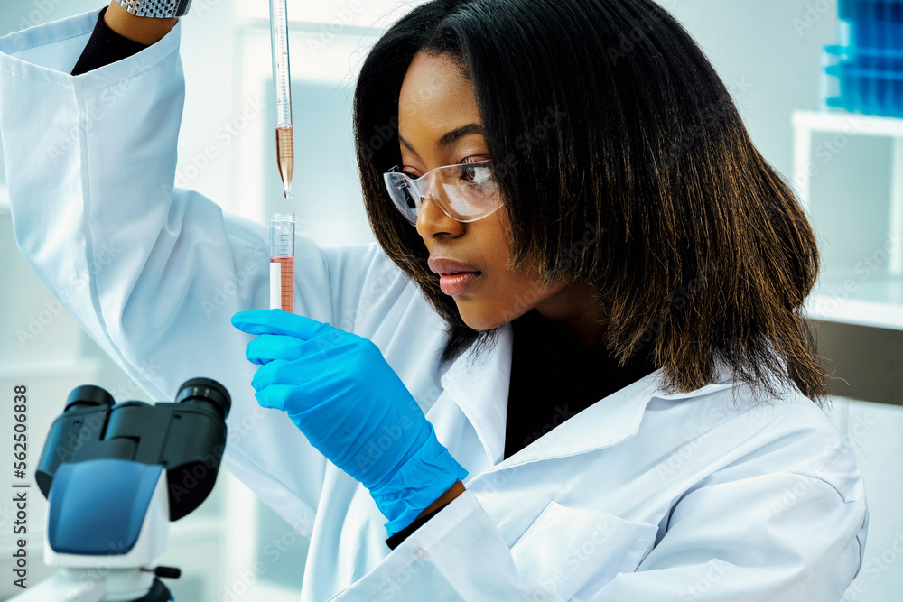 female scientist looking at test tube Stock Photo | Adobe Stock