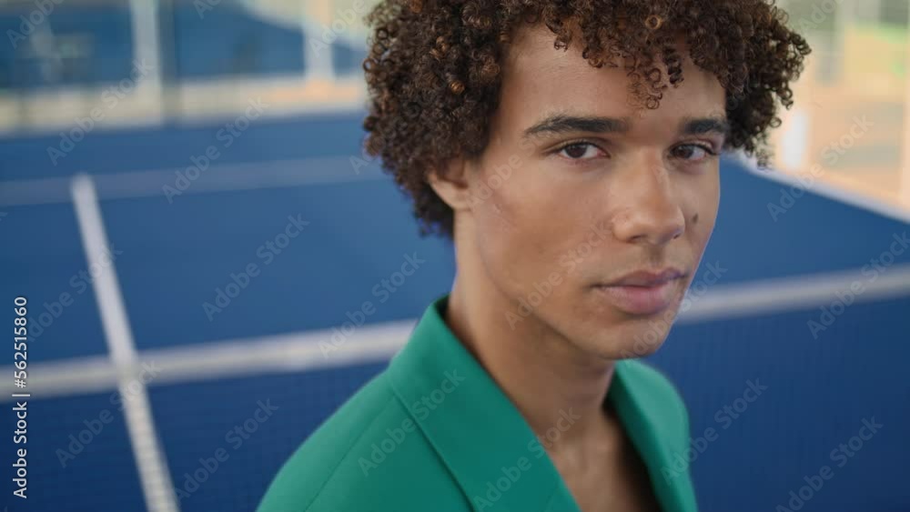 Curly teenager looking lens stadium background portrait. Serious model ...