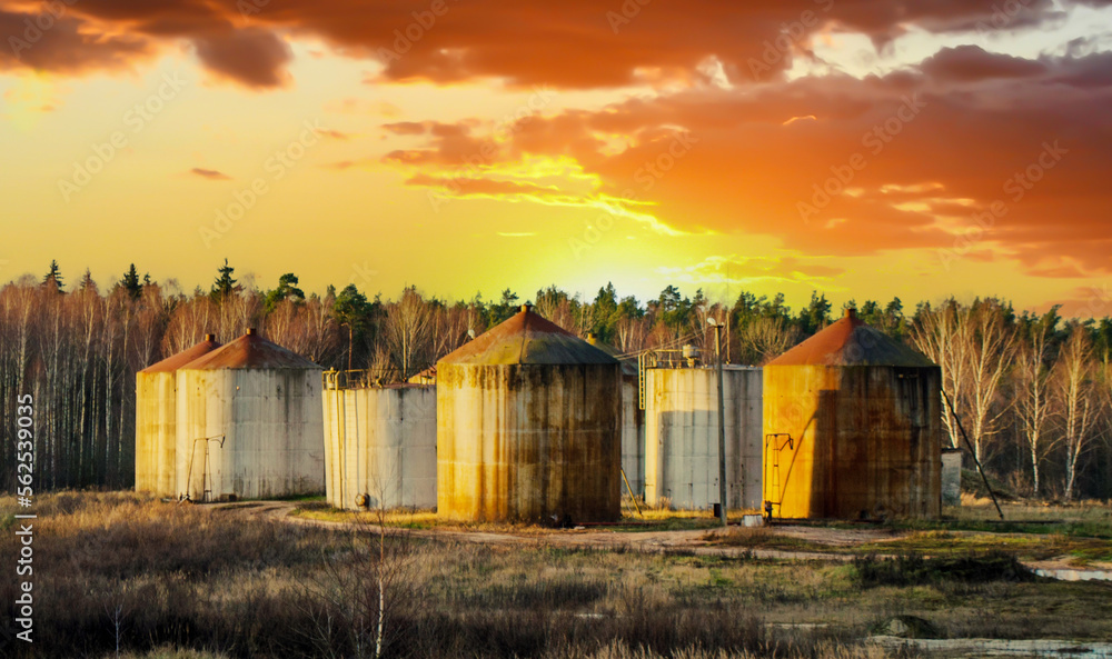 Oil storage at sunset. Abandoned crude oil storage in the forest. Old ...