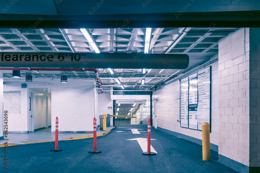 Entrance to an underground parking lot at night, red bollards block ...