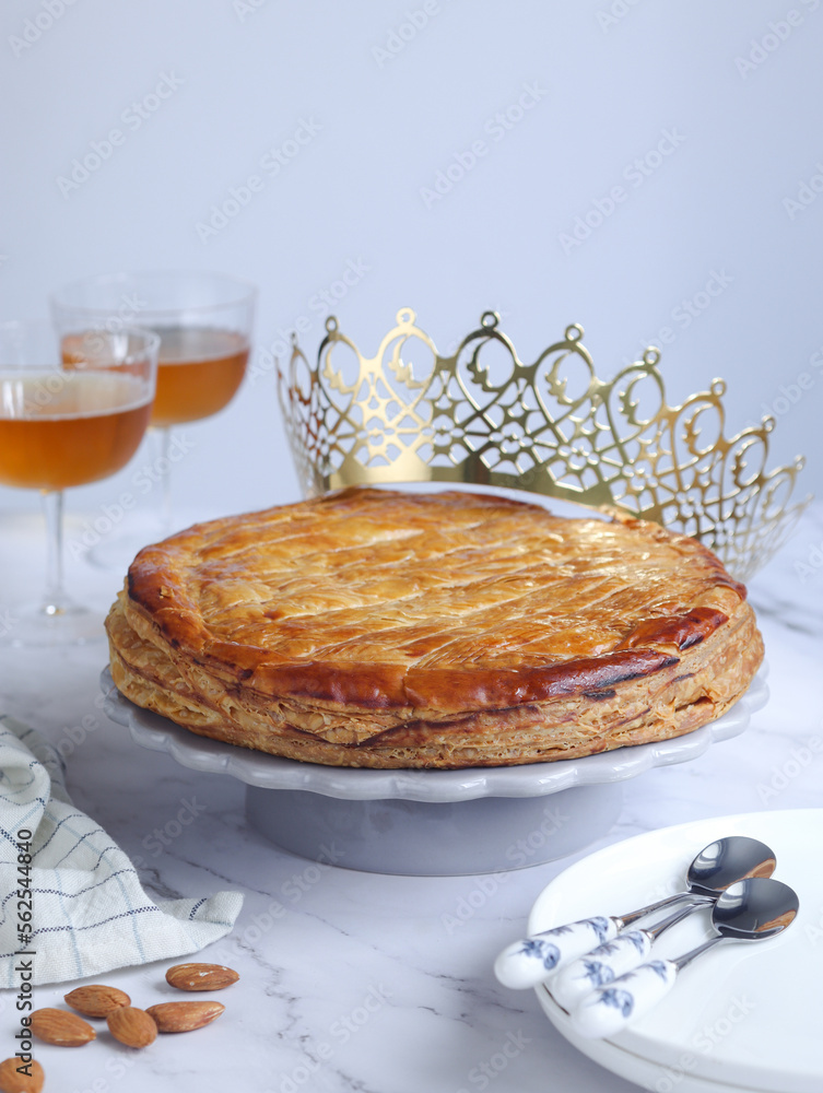 A traditional French galette des rois or king cake on a plate with ...