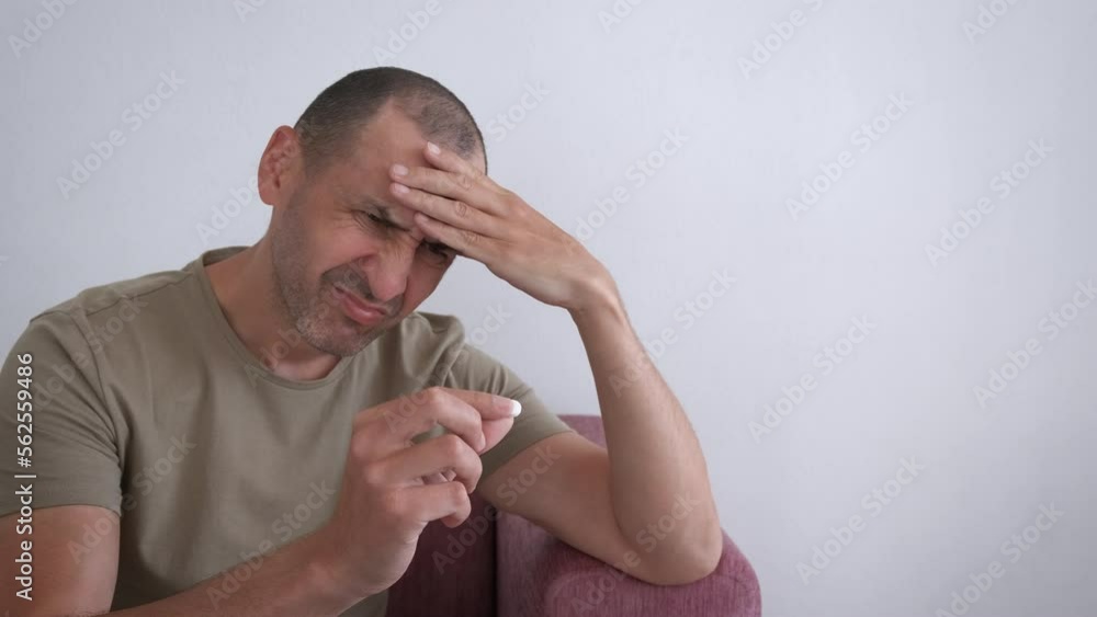 Suffering male with headache hold painkiller. A view of suffering man ...