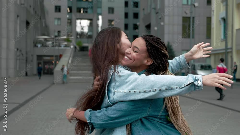 meeting of two girlfriends on the street in the afternoon African and ...