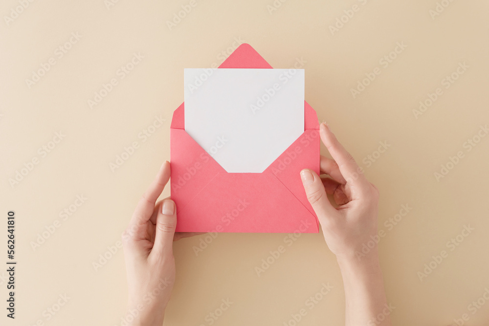 First person top view photo of female hands holding open red envelope ...