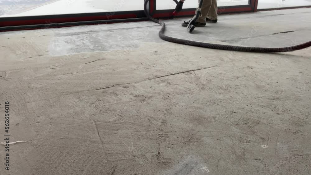 Construction works. The builder removes dust and small debris from the ...