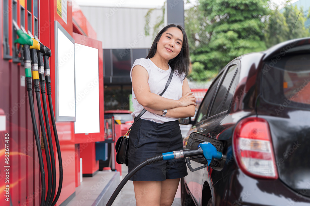 Car gas station at gas station A cute woman is standing and waiting ...