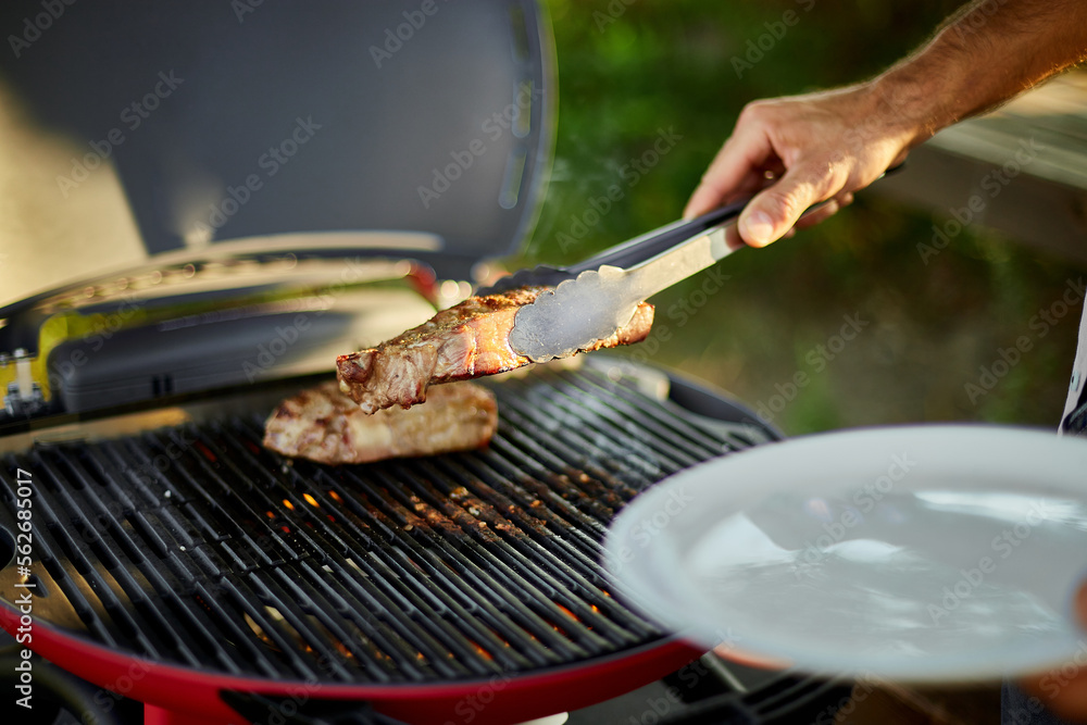 Foto de Man put down on a wooden board ready to eat grilled steak meat ...