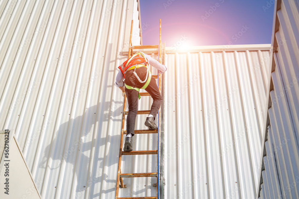 Construction worker wearing safety harness belt during working on roof ...