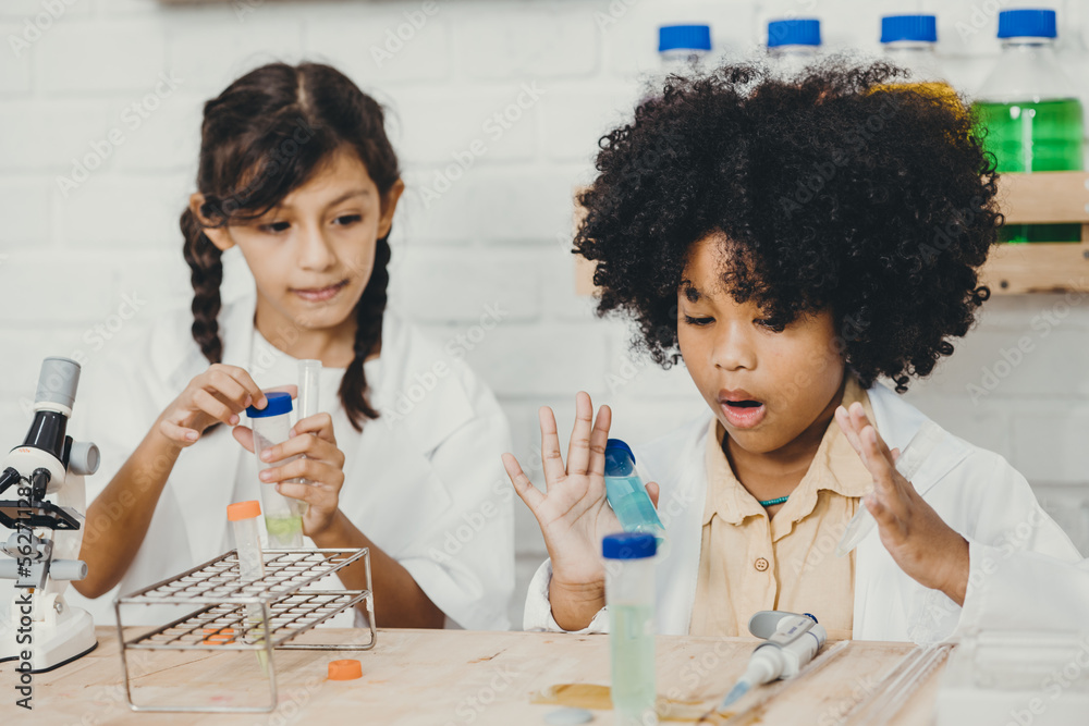 Young children playing exciting with chemistry science kits in school ...