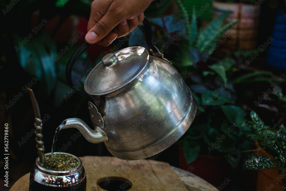 mano cebando mate, pava de acero y mate tradicional argentino con yerba ...