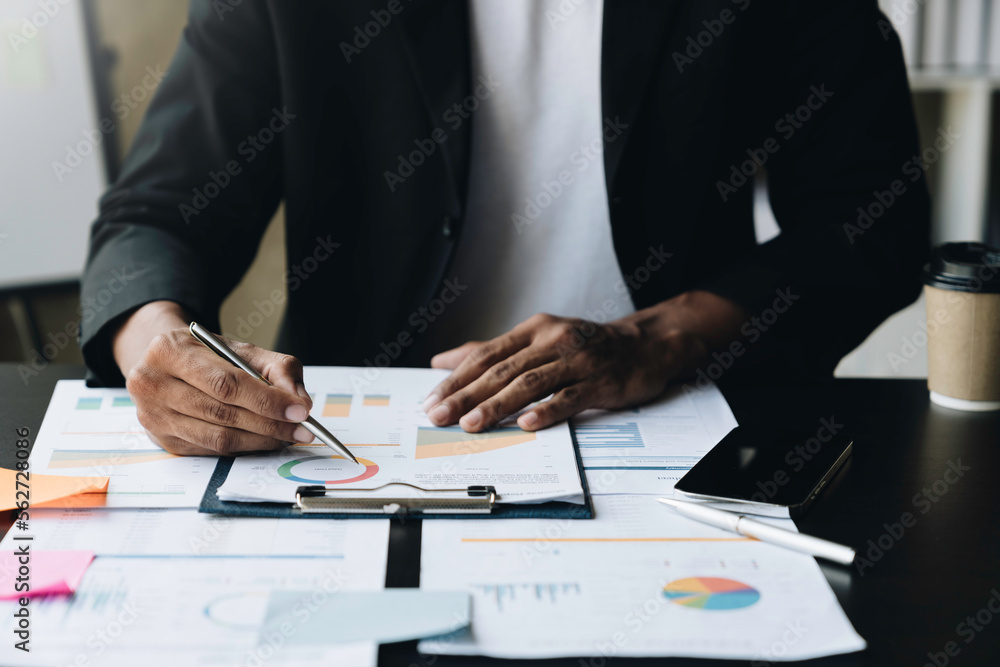 Young Asian businessman discussing graphs with hands and analyzing data ...