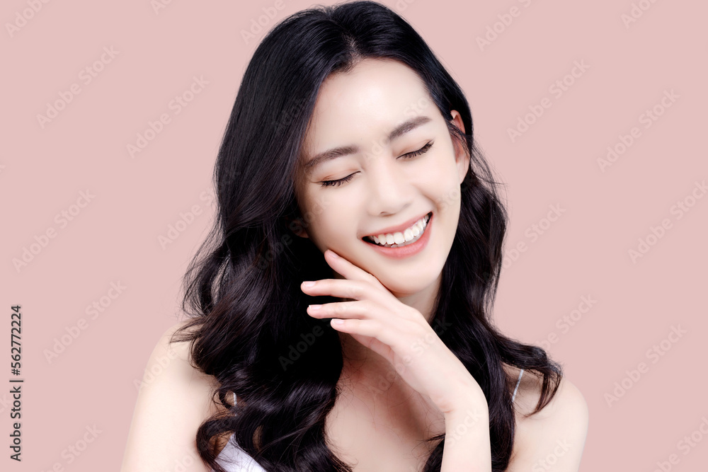 Beautiful Asian girl with long and shiny wavy hair isolated on pink ...