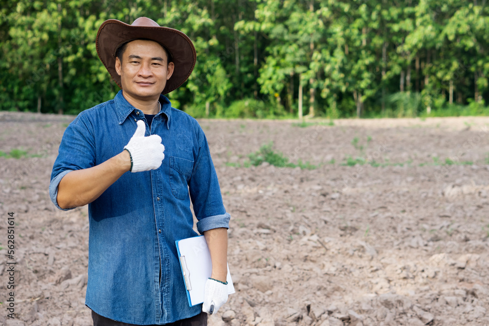 Foto de Asian man agronomist wears hat, blue shirt, holds paper ...