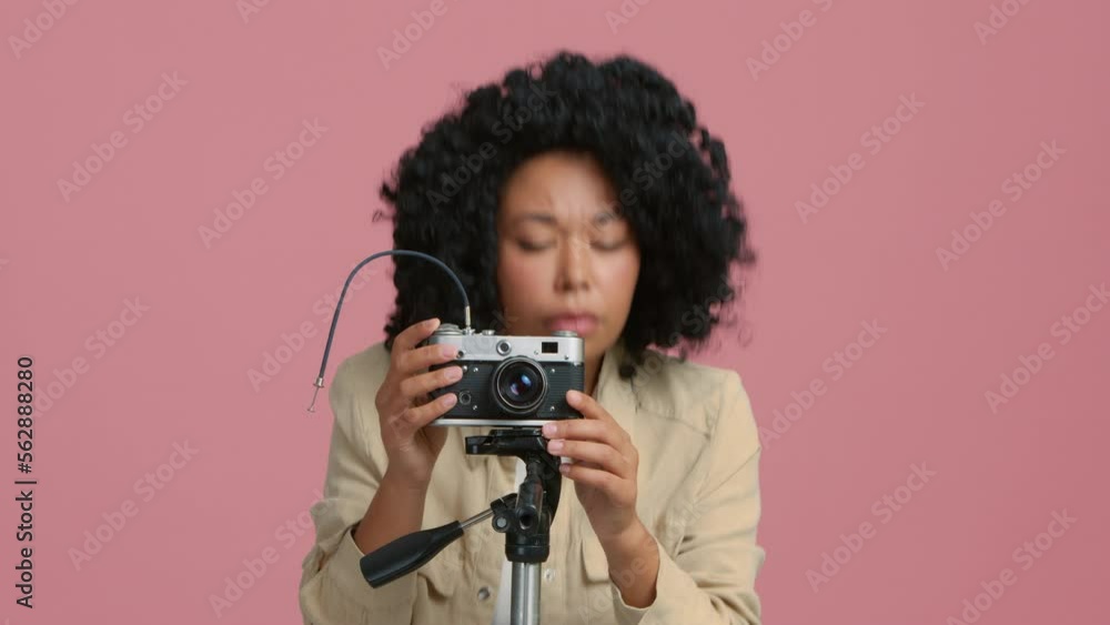 Serious female photographer capturing pictures with on film camera ...
