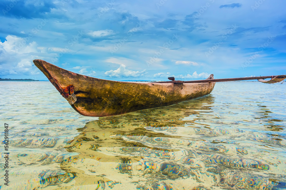 Wooden outrigger canoe anchored in a shallow tropical lagoon Stock ...