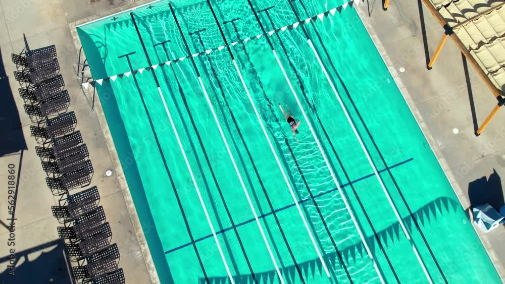 Aerial Birds Eye View Of Lone Female Swimming In Olympic Size Pool On ...