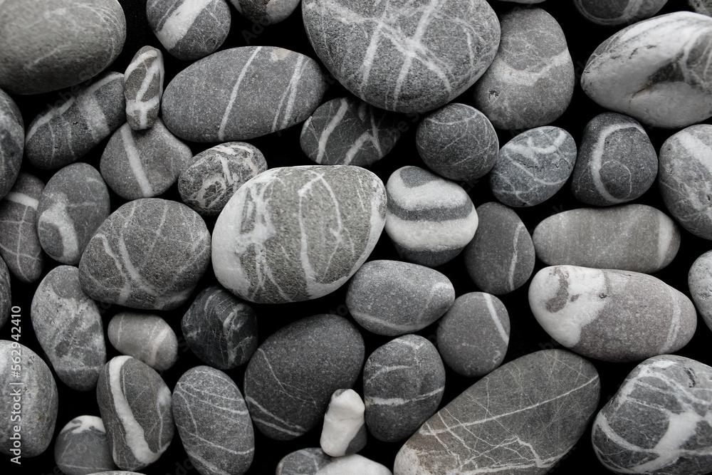 Texture effect from gray pebbles marked with white streaks laid out on ...