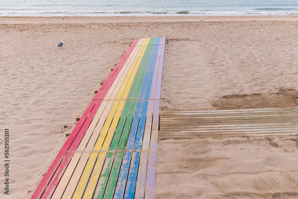 Pasarela de madera para entrar en la playa pintada con los colores del ...