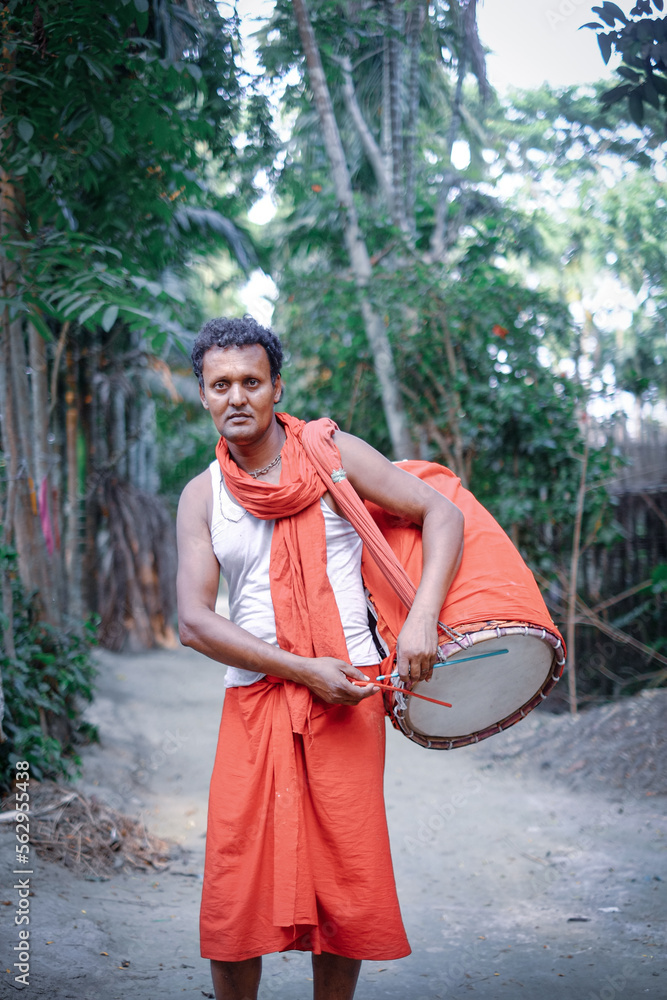 Hindu religious middle aged man playing traditional musical instrument ...