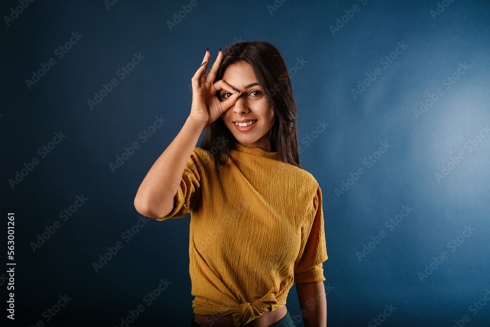 Young woman smiling confident wearing yellow t-shirt isolated over blue ...