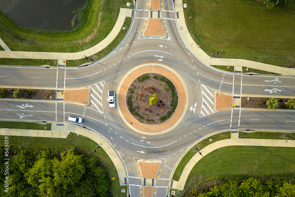 Aerial view of road roundabout intersection with moving cars traffic ...