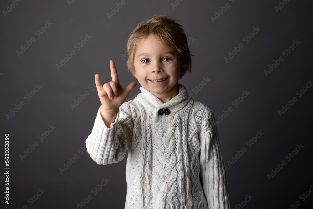 Cute little toddler boy, showing I LOVE YOU gesture in sign language on ...