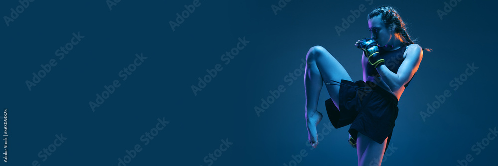 Leg kick. Young woman athletic female MMA fighter training isolated on ...