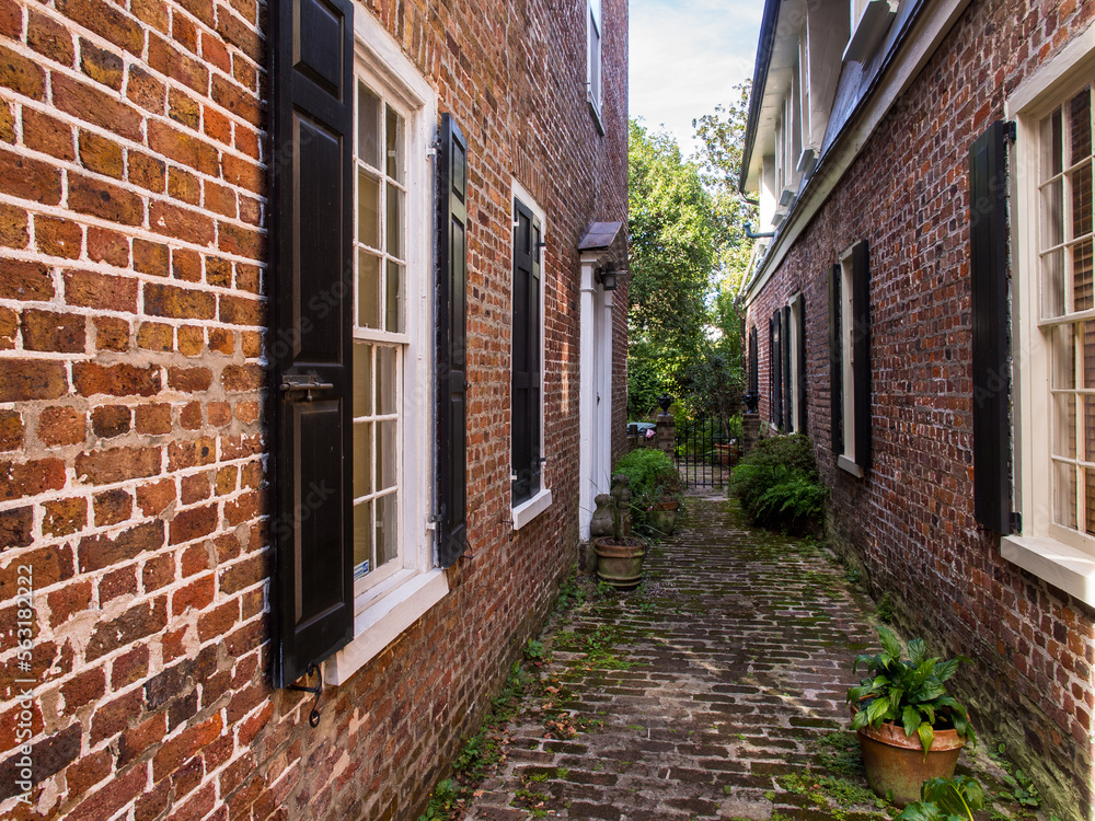 Narrow brick path between two red, historic brick houses in Savannah ...
