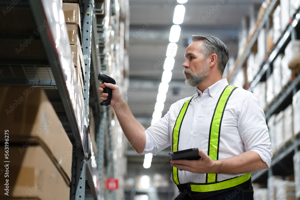 Senior warehouse manager scan boxes by using scanner to count inventory ...