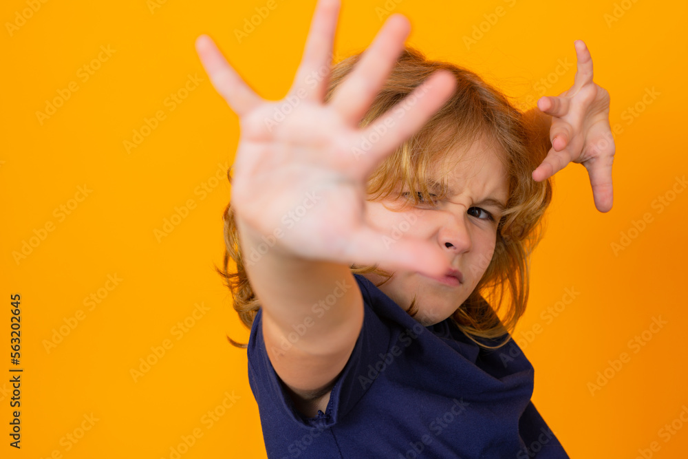 Child making stop gesture on yellow isolated studio background. Kid ...