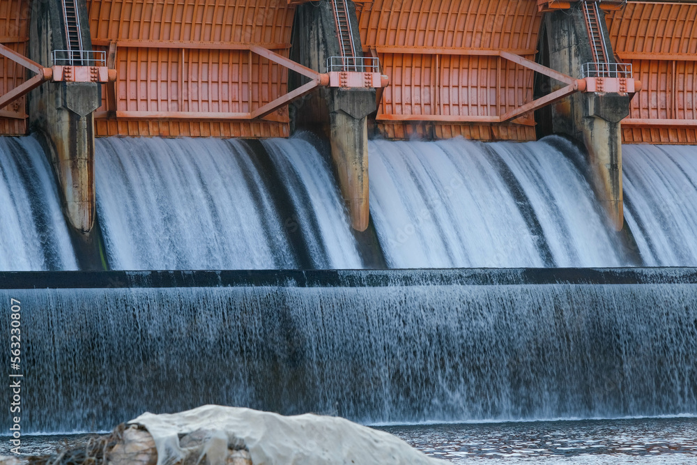 Hydroelectric dam, floodgate with flowing water through gate and open ...