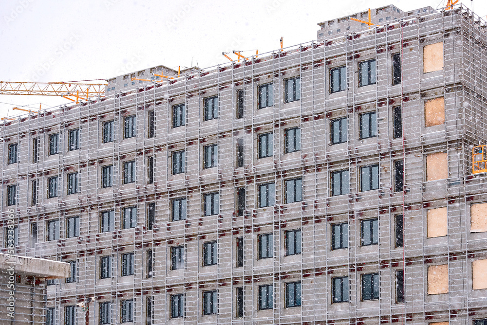 Insulation of building during winter snow storm. Cladding of building ...