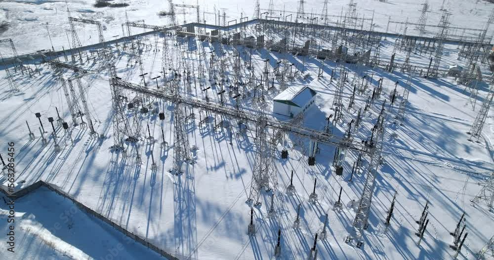 Aerial view of an Electrical Substation in winter with high pylons and ...