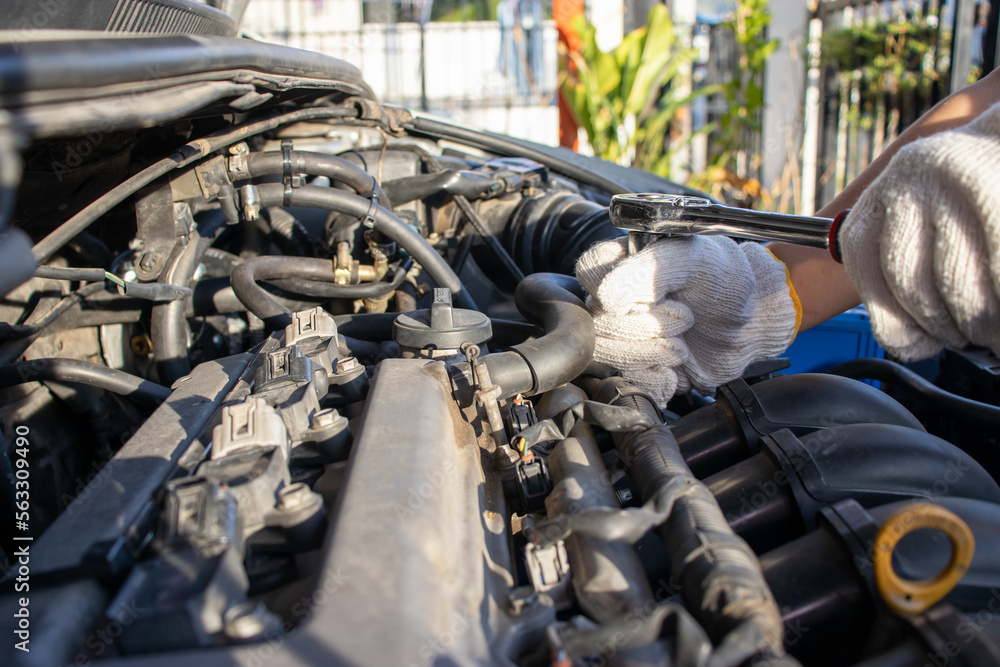 Mechanic checking vehicle repairs Mechanic using wrench to check engine ...